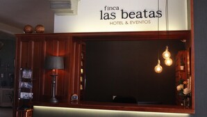 Uma área de recepção com uma placa indicando "Finca las beatas HOTEL & EVENTOS".