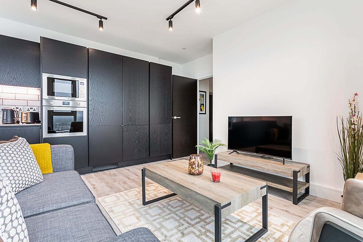 Uma sala de estar moderna com sofá, mesa de centro e televisão.