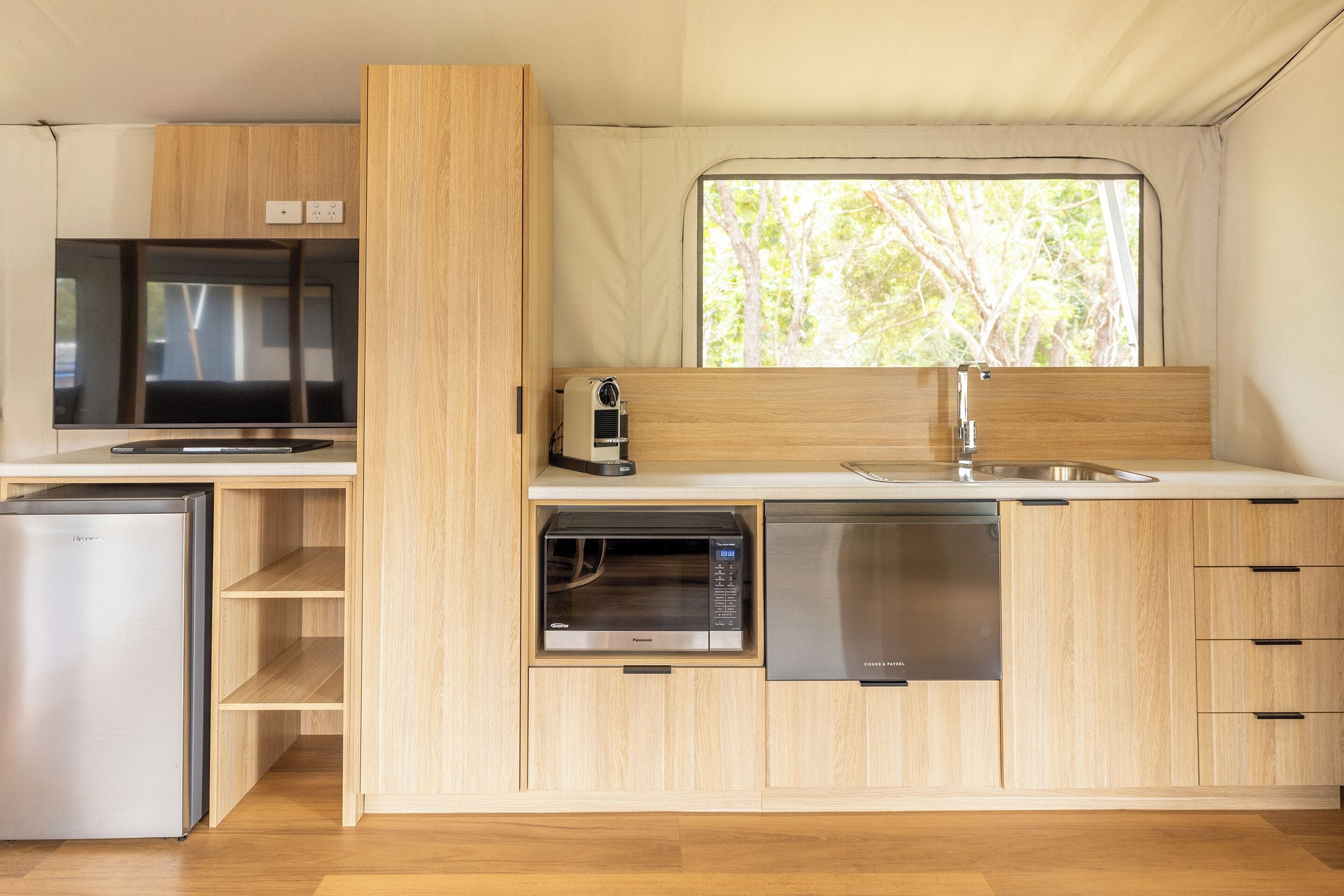 Cozinha compacta com micro-ondas, lava-louças e pia.