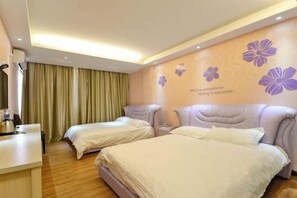 Quarto de hotel com duas camas, uma escrivaninha e uma parede decorada com motivos florais.