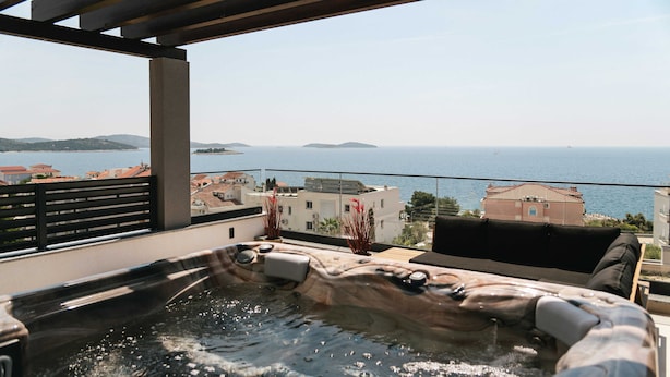 Uma banheira de hidromassagem com vista para o mar e edifícios.
