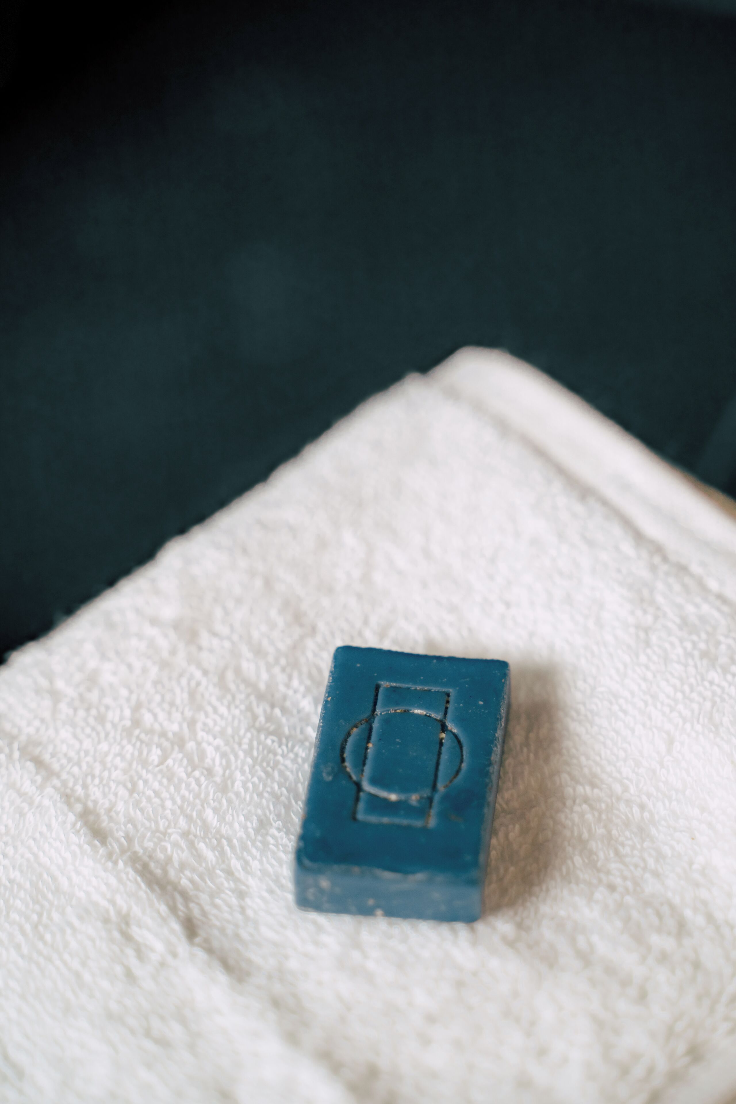 Um pequeno objeto azul sobre uma superfície branca texturizada.
