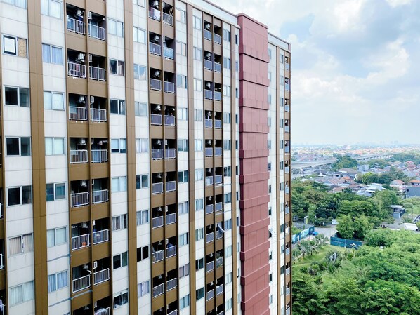 Um edifício alto com várias varandas e vista para o horizonte urbano.