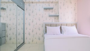 Quarto com cama, guarda-roupa, porta de vidro e parede estampada.