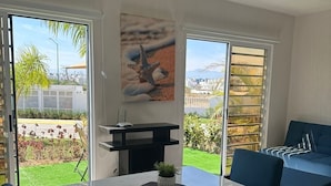 Uma sala de jantar moderna com uma mesa e cadeiras, um vaso de planta e um quadro sobre a mesa.