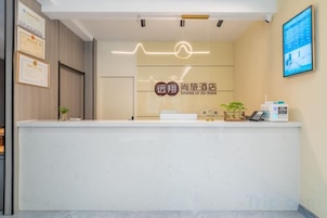 Balcão de recepção com placa, certificados e um quadro na parede.