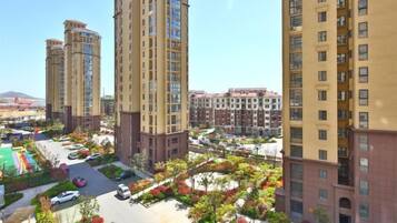 Zona residencial com edifícios altos, uma avenida central e jardins bem cuidados.