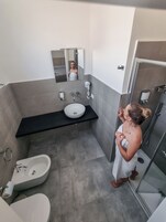 Um polibã, um chuveiro fixo, um secador de cabelo, um bidé 