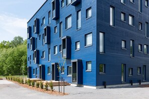 Um edifício moderno azul com várias janelas e varandas.