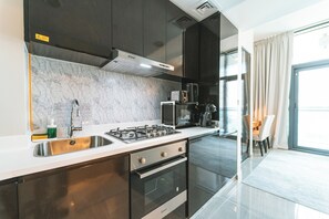 Um micro-ondas, um forno, uma placa de cozinha, uma chaleira elétrica