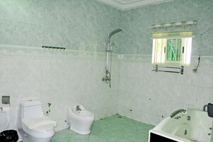 Casa de banho com sanita, bidé, chuveiro e banheira.