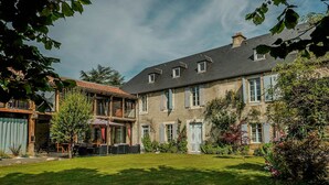 Uma casa de dois andares com gramado bem cuidado e um espaço de varanda.