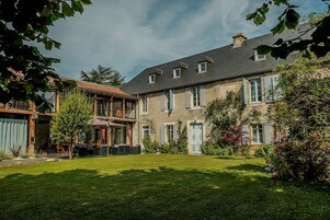 Uma casa de dois andares com gramado bem cuidado e um espaço de varanda.