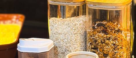 Estação de bebidas com serviço próprio, com diversos recipientes de café, chá e outras bebidas.