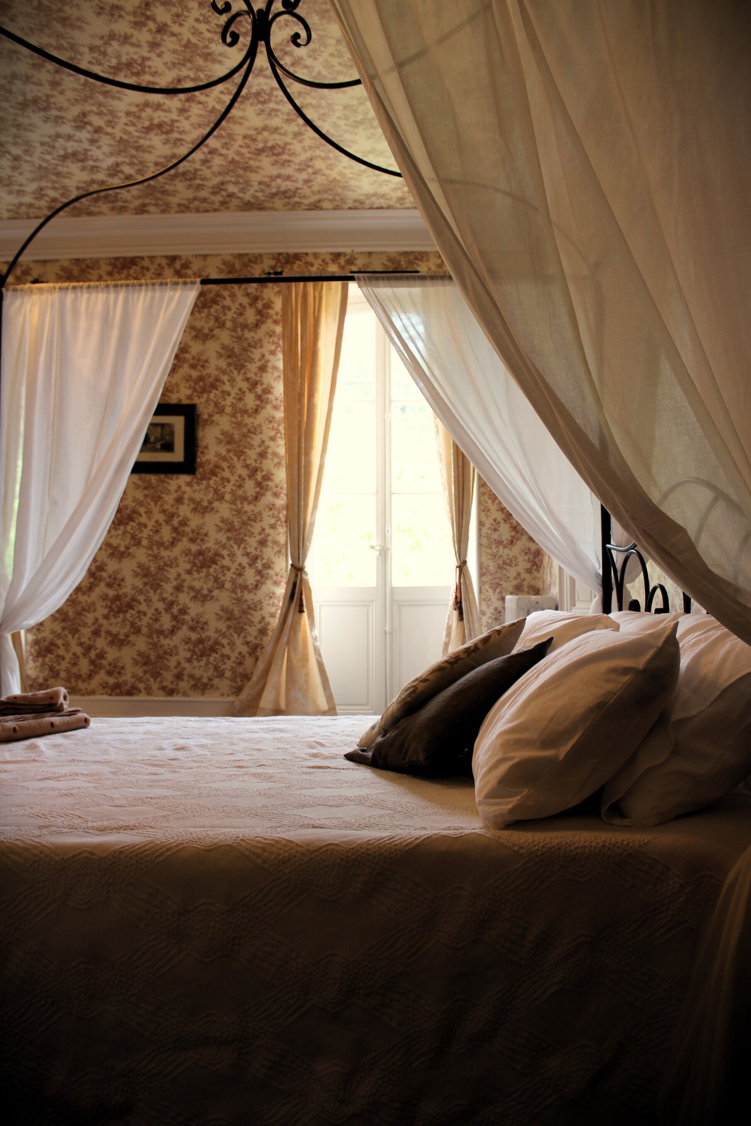 Quarto com cama, cortinas e janela.