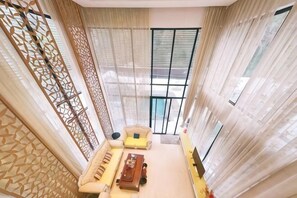 Um quarto com sofá, mesa de centro e um biombo decorativo.