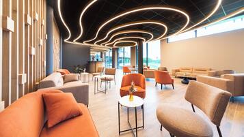 Uma área de estar moderna com sofás, poltronas e uma mesa de centro.
