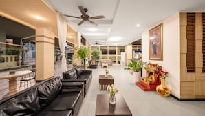 A spacious lounge area with leather sofas, a coffee table, and potted plants.