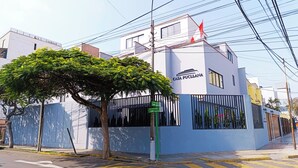 Um edifício moderno com uma placa indicando “CASA PUCCLANA” e uma árvore na frente.