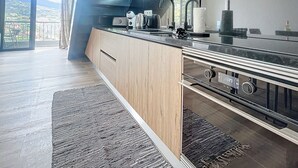 Uma cozinha moderna com armários de madeira, fogão de aço inoxidável e uma grande janela com vista panorâmica.