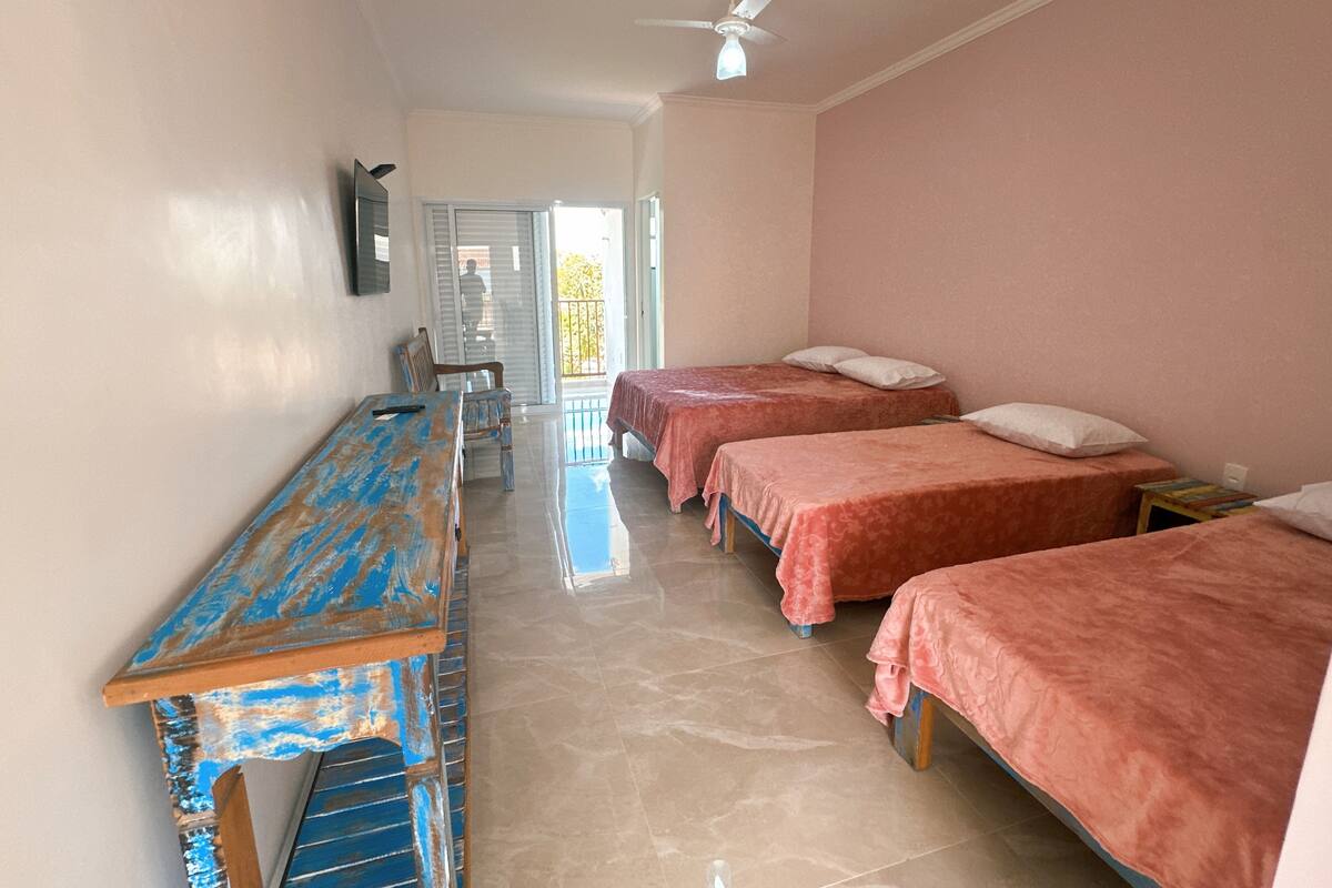 Quarto com duas camas, uma mesa e uma cadeira.