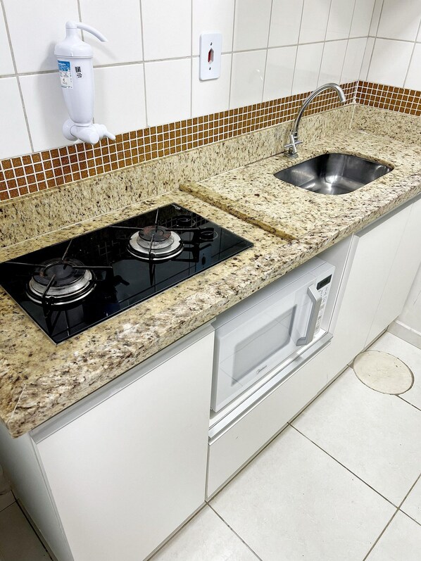 Um micro-ondas, uma placa de cozinha, utensílios de cozinha, Congelador