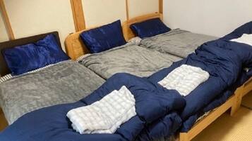 Quarto com uma cama, cabeceira de madeira e um pequeno banquinho.