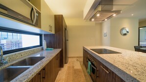 Uma cozinha moderna com bancadas de granito, eletrodomésticos de aço inoxidável e armários de madeira.