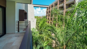 Um edifício moderno com varanda com vista para um jardim exuberante.