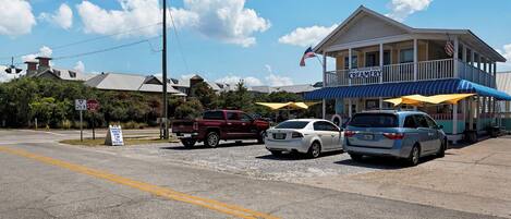 Um edifício com toldo azul e uma bandeira americana, com a inscrição "Blue Mountain Beach Creamery".
