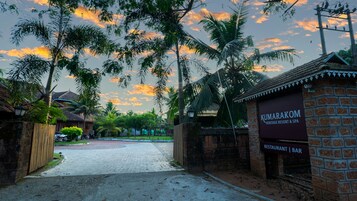A heritage resort with a brick building labeled "KUMARAKOM HERITAGE RESORT & SPA RESTAURANT | BAR".