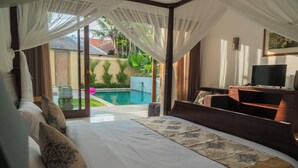 Quarto com cama grande, televisão e vista para uma piscina.