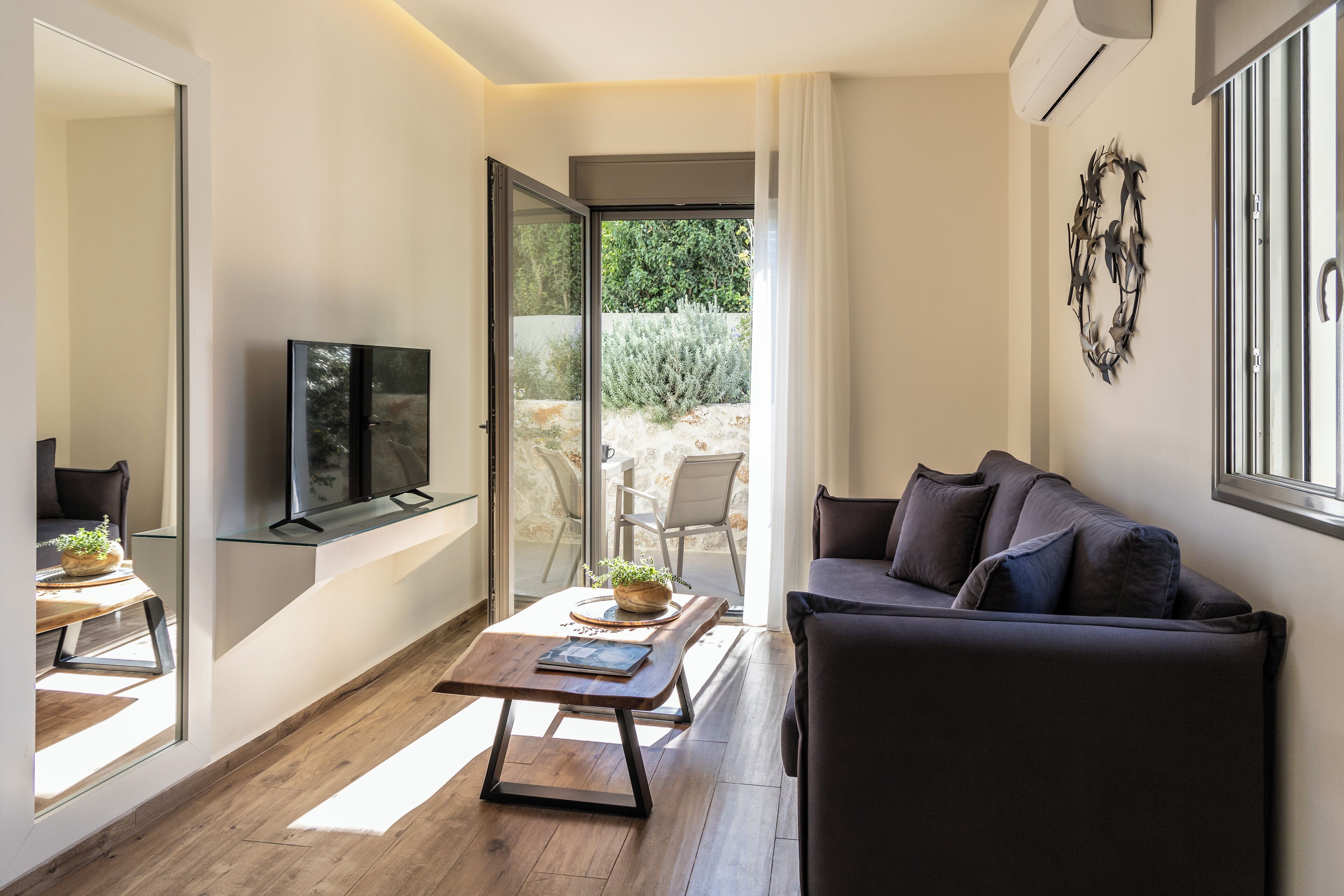Uma sala de estar moderna com um sofá, uma mesa de centro e uma televisão.