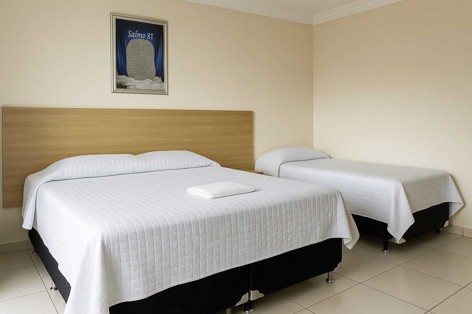Quarto de hotel com duas camas, cabeceira de madeira e um quadro na parede.