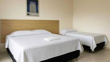 Quarto de hotel com duas camas, cabeceira de madeira e um quadro na parede.