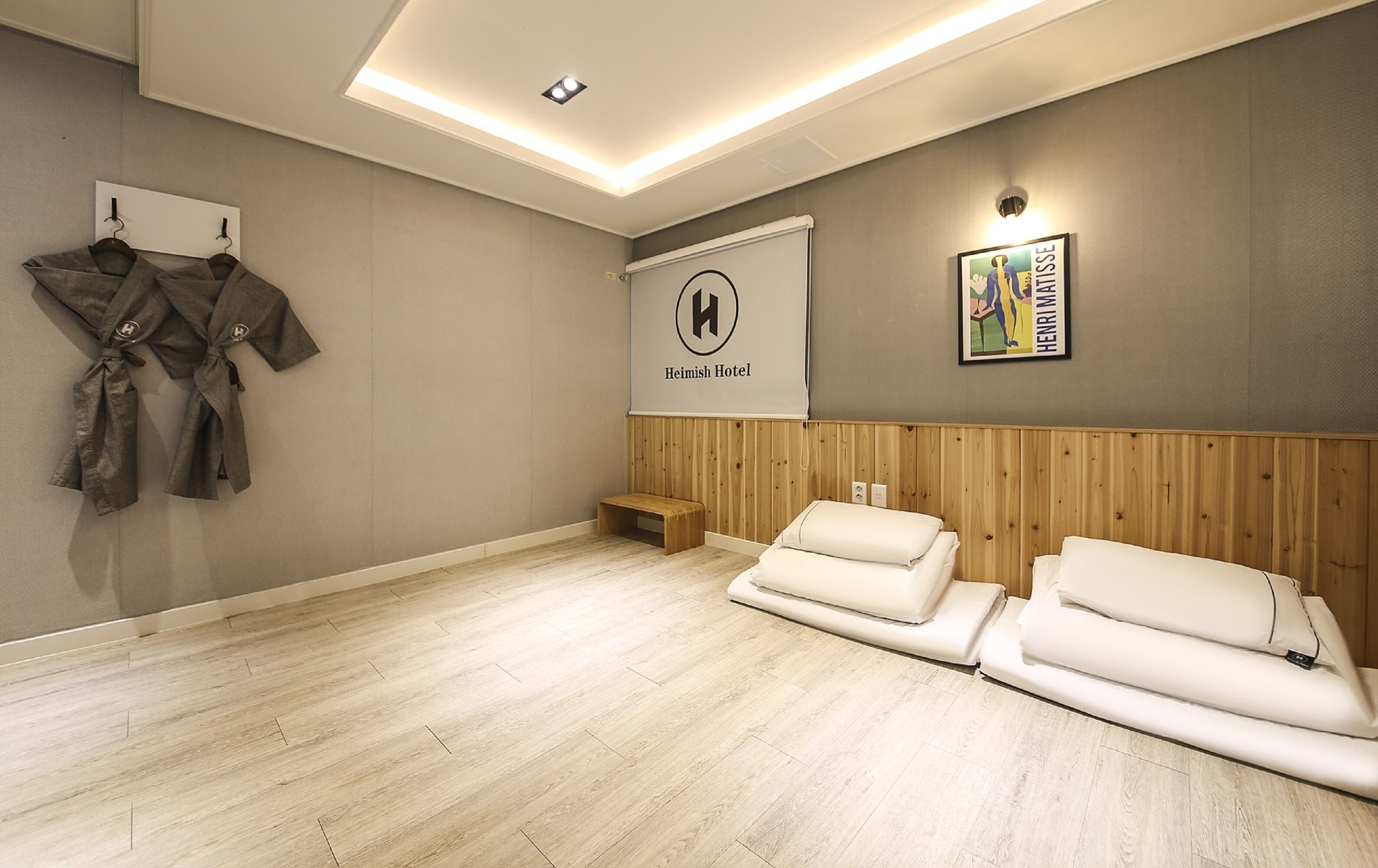 Um spa moderno com painéis de madeira, um banco e uma mesa de massagem.