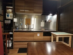 Uma cozinha moderna com armários de madeira, eletrodomésticos de aço inoxidável e lava-louças embutida.