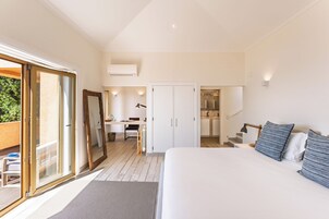 Quarto com uma cama grande, uma escrivaninha e um guarda-roupa.