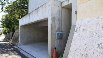 Uma estrutura de concreto com parede de pedra, calçada e um cone de trânsito.