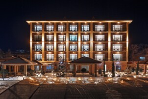 Hotel de vários andares com fachada simétrica, várias varandas e área de entrada coberta.