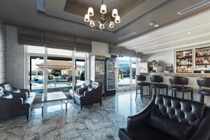 Um lobby moderno com área de bar, assentos e amplas janelas.