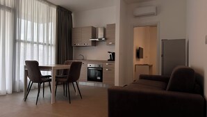 Cozinha moderna com área de refeições, incluindo mesa, cadeiras e forno embutido.
