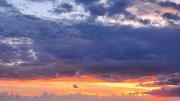 Uma praia com um pôr do sol e nuvens.