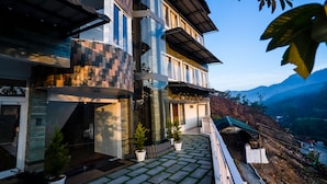 Uma casa moderna de vários andares com fachada de pedra, grandes janelas e entrada com calçada.