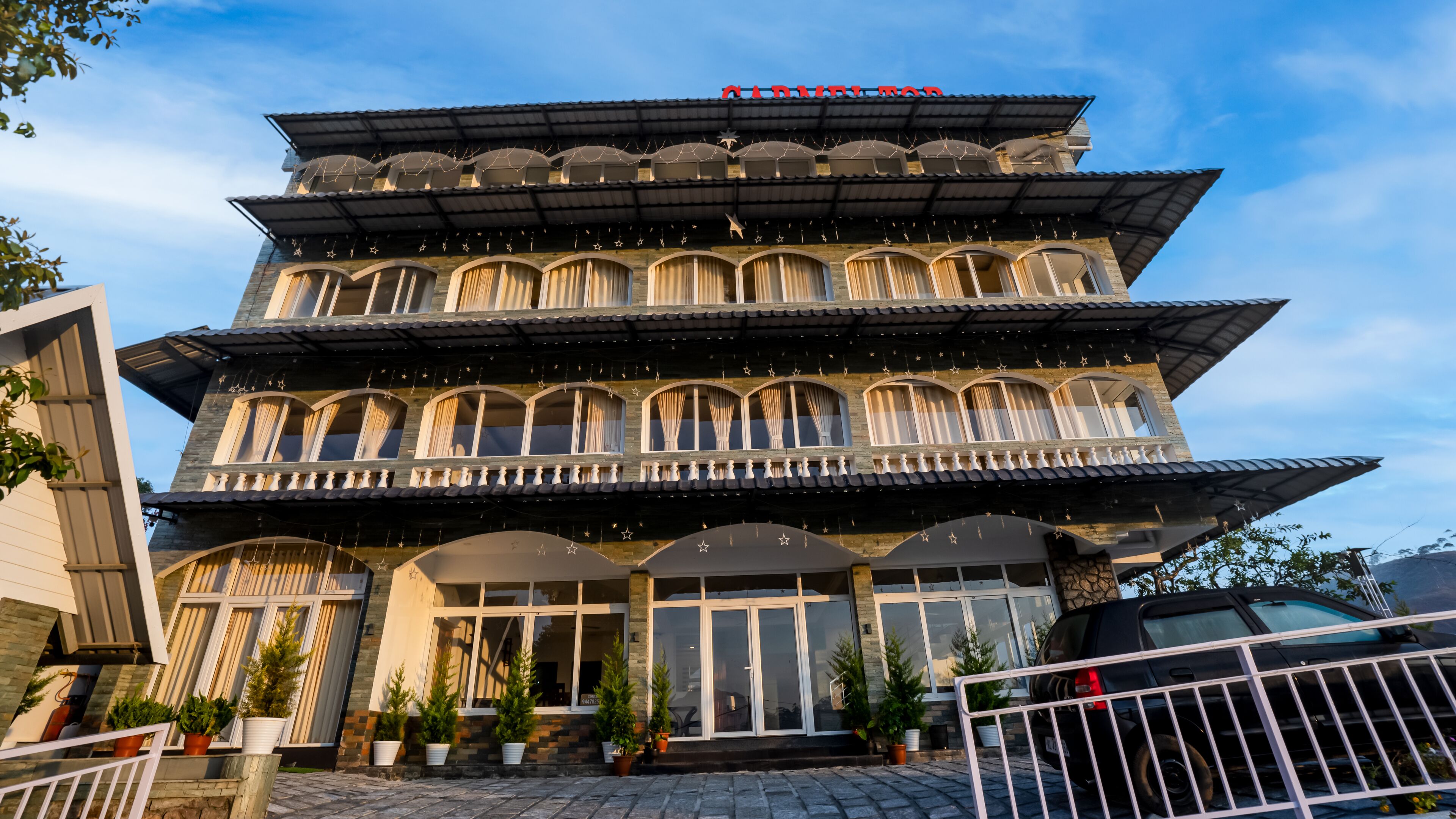 Hotel de vários andares com estilo arquitetônico tradicional, com varandas com cortinas e detalhes em forma de estrela.