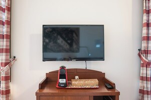 Televisão de tela plana presa na parede acima de um console de madeira.