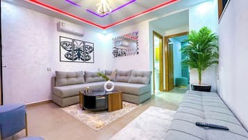 Apartamento luxo, vista para o jardim | Área de estar | Smart TV 65 polegadas com canais via satélite, Netflix