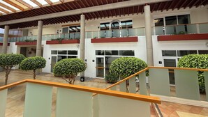 Um amplo átrio com teto alto, vários andares e escadaria central.