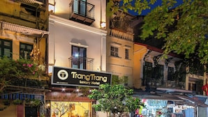 Um edifício de vários andares com a placa do Hotel de Luxo Trang Trang.
