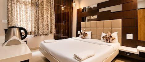 Quarto de hotel moderno com uma cama grande, uma cafeteira e um guarda-roupa.